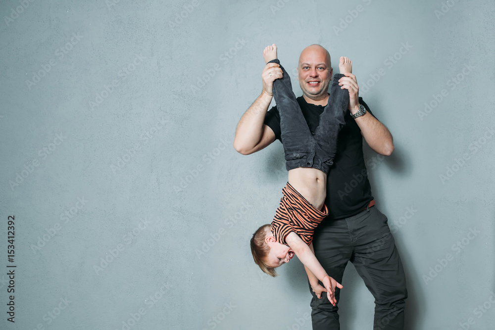 funny young dad keeps his son's legs upside down Stock Photo | Adobe Stock