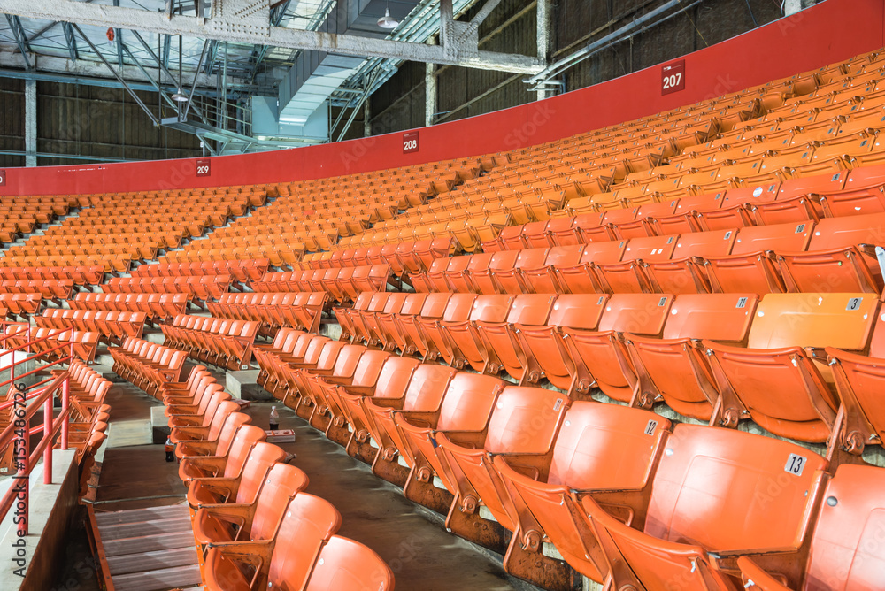 Rows of multilevel empty orange metal grandstand seats with number at ...