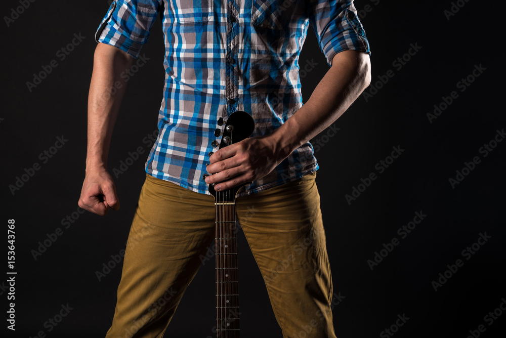 Music and art. The guitarist holds an electric guitar in his left hand ...