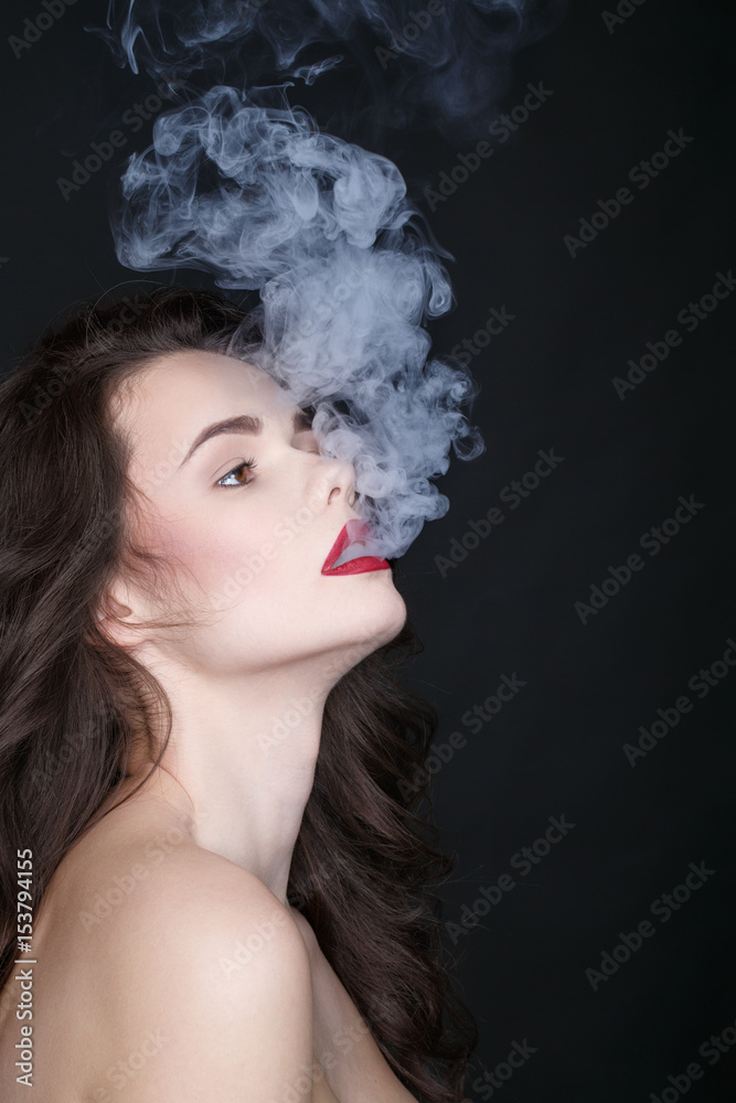Beautiful smoker. Vertical studio portrait of a gorgeous young model ...