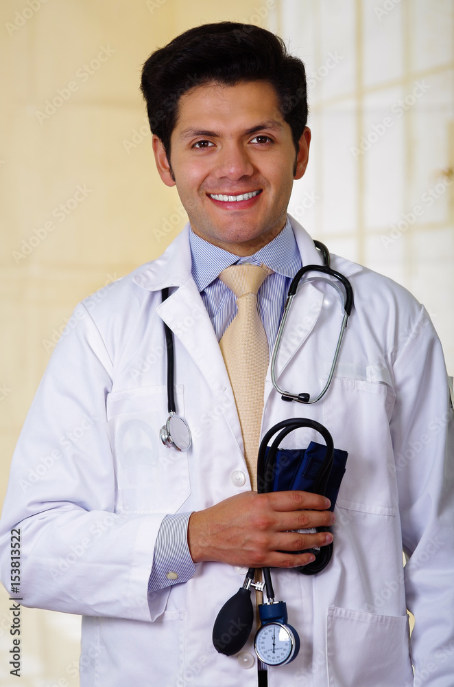 Confident handsome smiling doctor posing and looking at camera with an ...