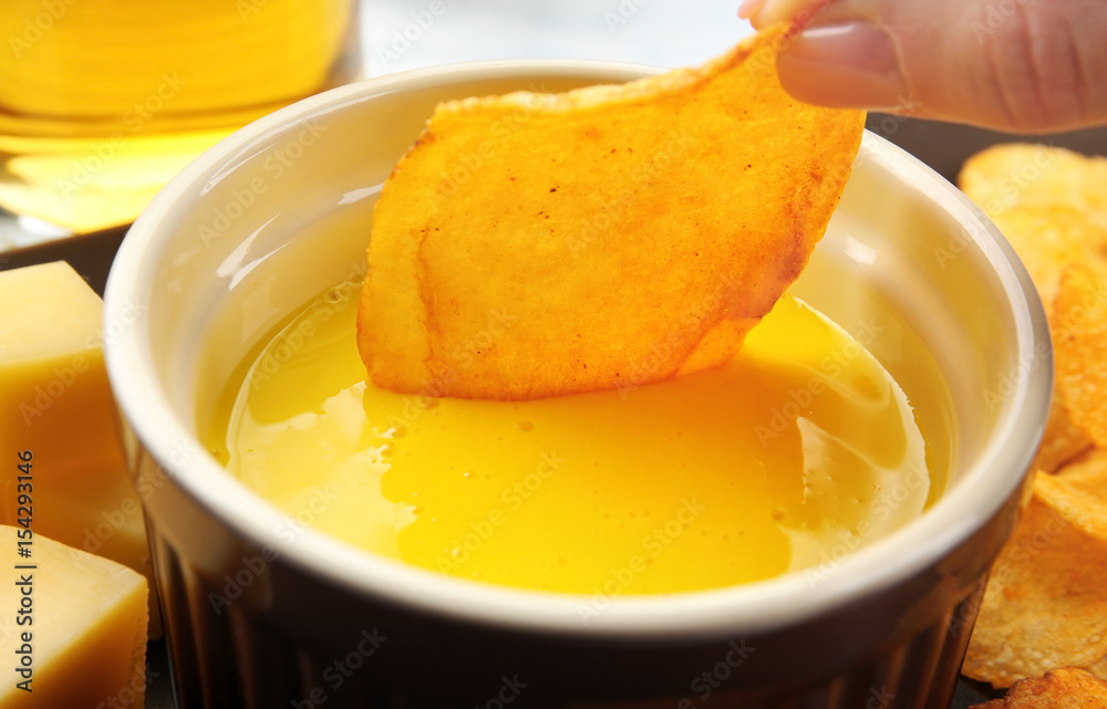 Woman dipping chips into bowl with creamy cheese sauce, close up Stock ...