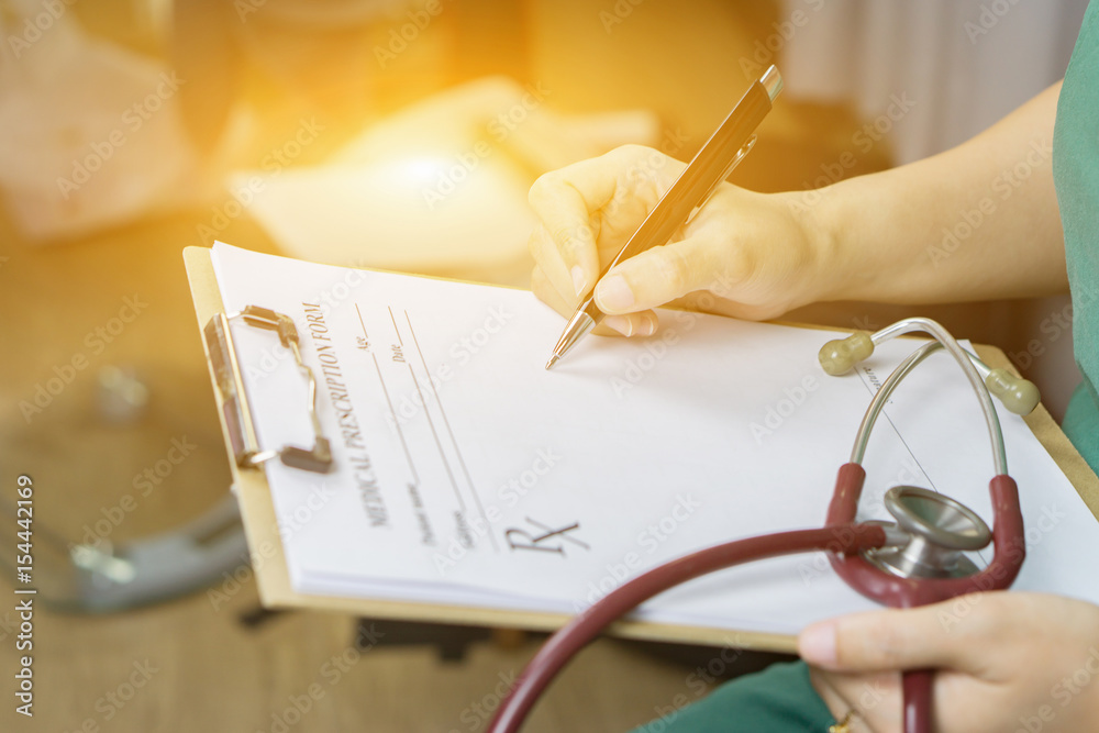 female doctor writing a prescription with stethoscope on hospital ...