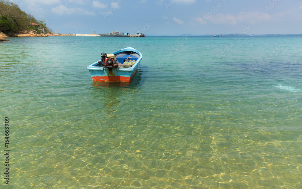 Seaside beach view with fisher boat see through the water to sebase ...