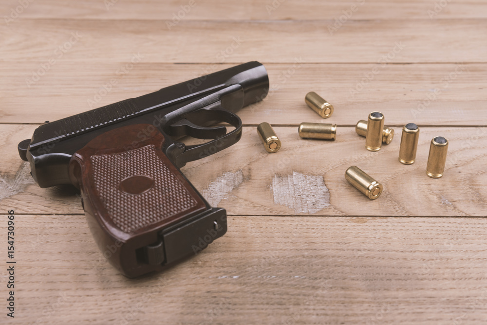 Traumatic pistol with bullets and cartridge on the wooden surface, set ...