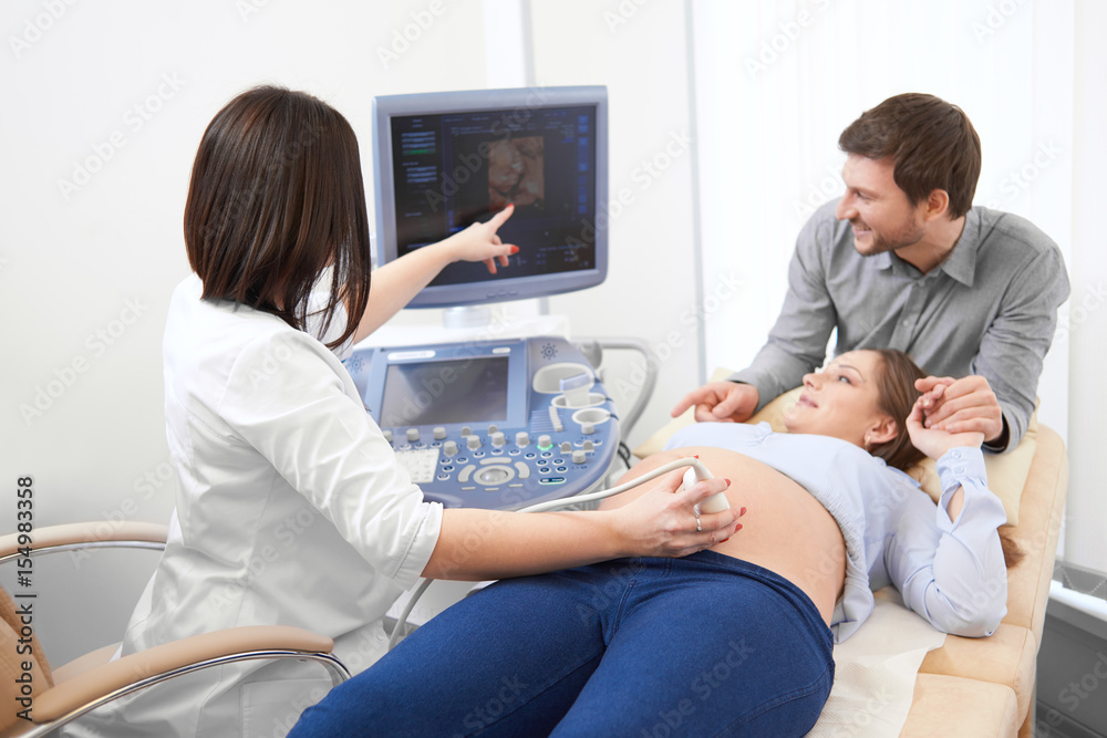 Female doctor showing at screen of computer first photo of baby in ...