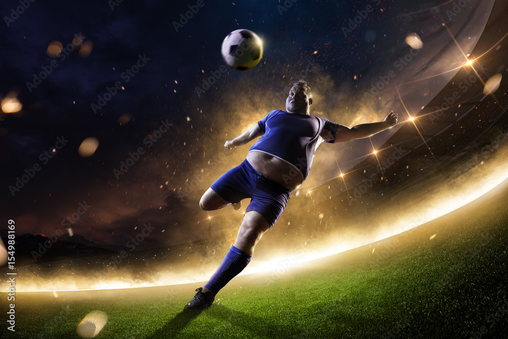 fat soccer player in action. stadium in fire night Stock Photo | Adobe Stock