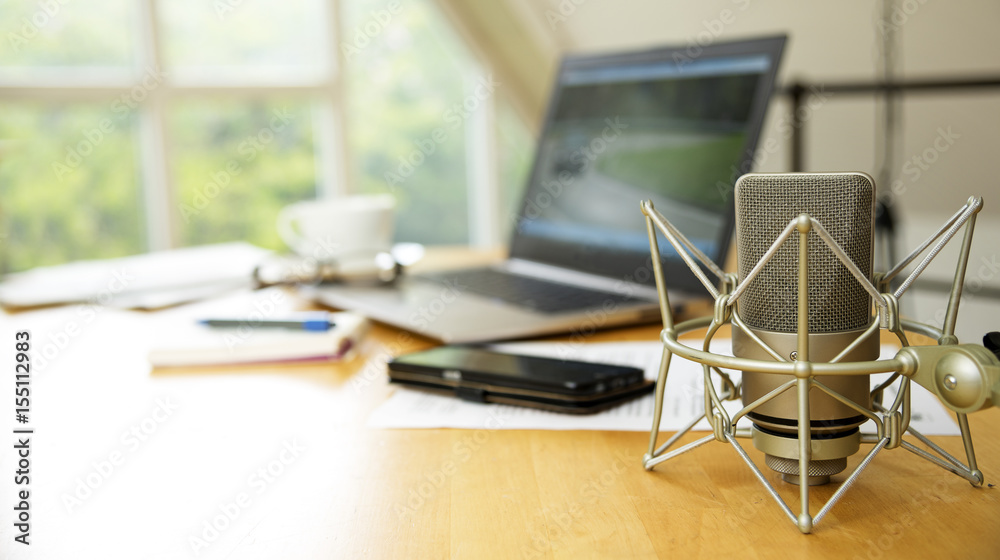 workspace for journalism with condenser microphone, laptop, cellphone ...