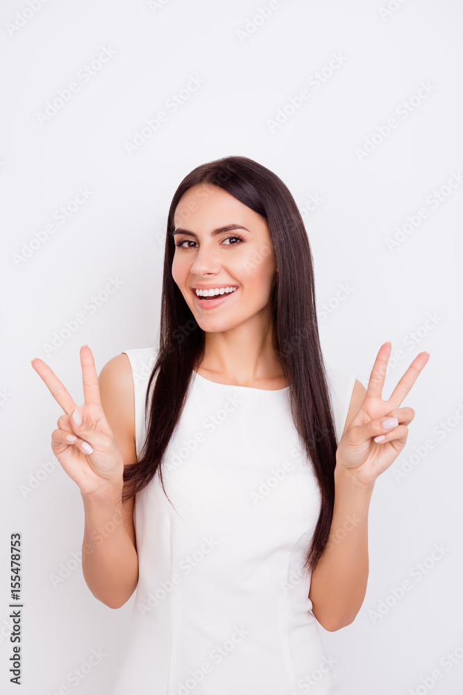 Portrait of cheerful cute brunette woman showing two fingers with her ...