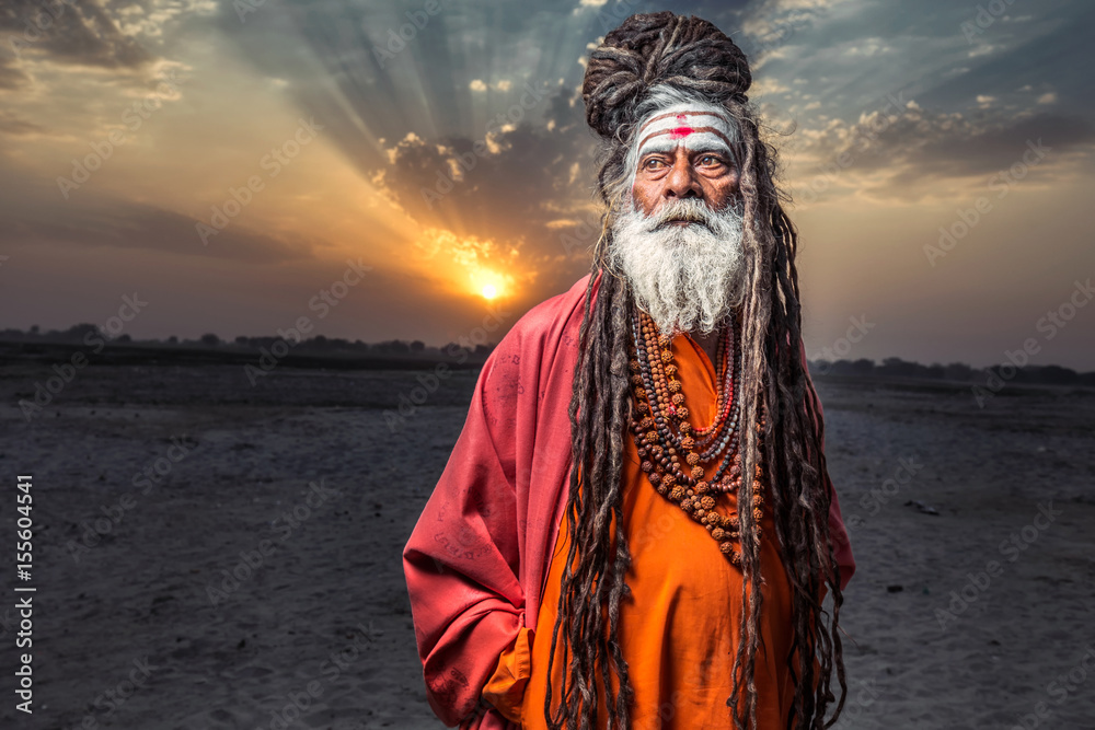 Portrait of sadhu standing with sunrise behind him, Varanasi, India ...