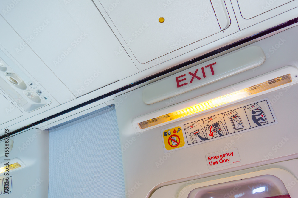 Exit sign and symbols in an aircraft cabin Stock Photo | Adobe Stock