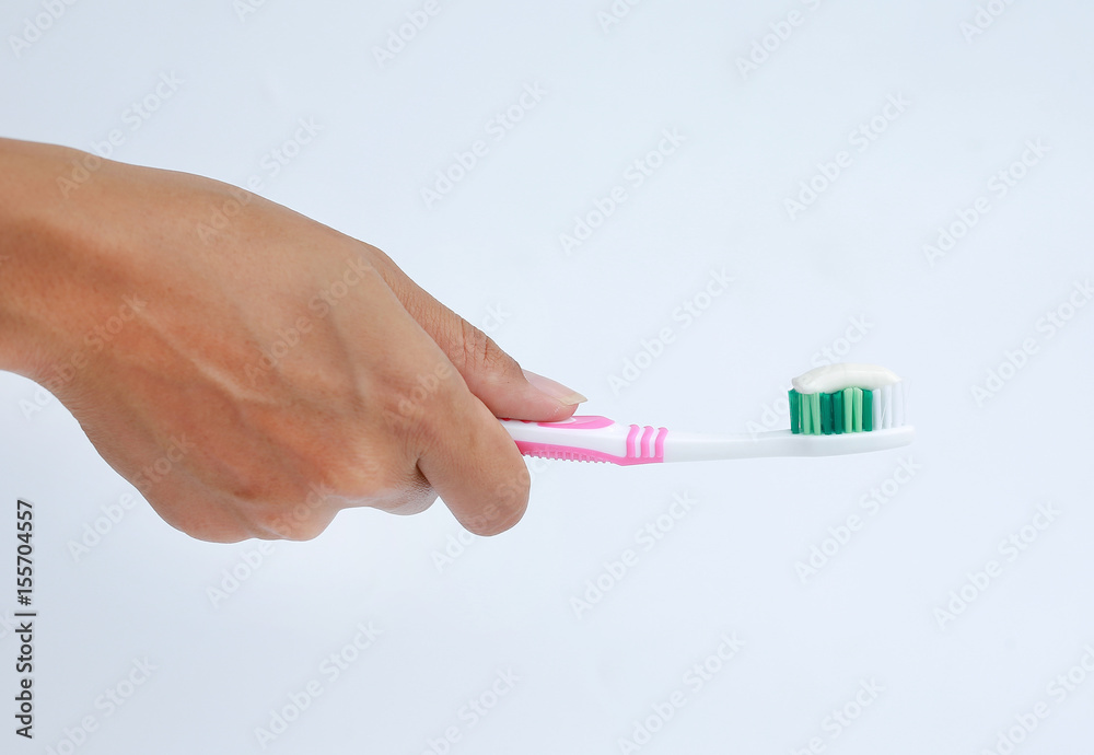 woman holding a toothbrush and placing toothpaste on it. Stock Photo ...