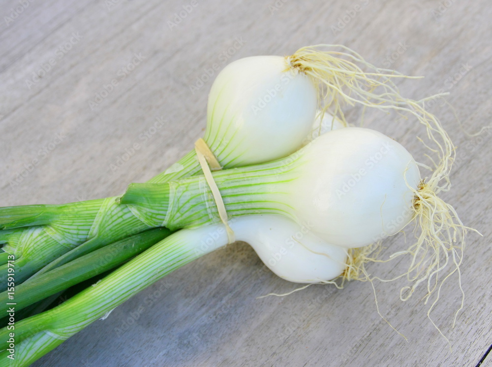 botte d'oignons blancs sur fond bois Stock Photo | Adobe Stock