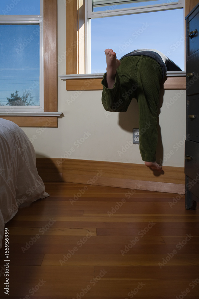 Boy climbing out of window Stock Photo | Adobe Stock