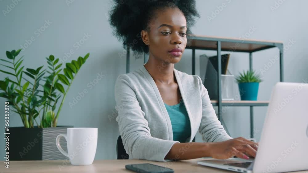 Beautiful african american woman working with laptop computer at the ...
