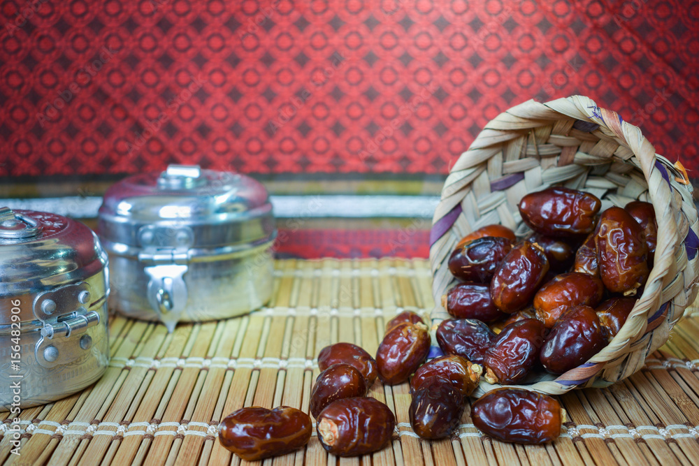Dates in wooden basket made of palm leaves with traditional Arabic ...
