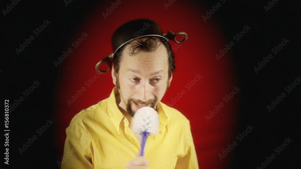 A Funny Ugly Man Singing While Wearing A Pot As A Hat And Using A
