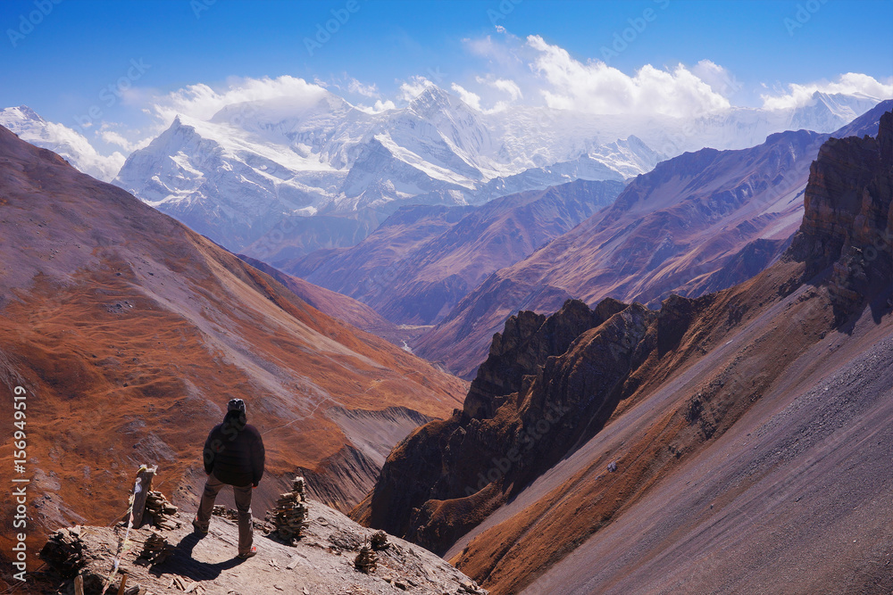 Himalaya mountains. Man, tourist, stands on a cliff watching highland ...
