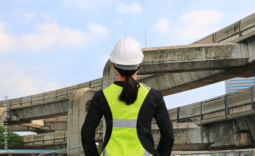 Back view of female construction worker against expressway background ...