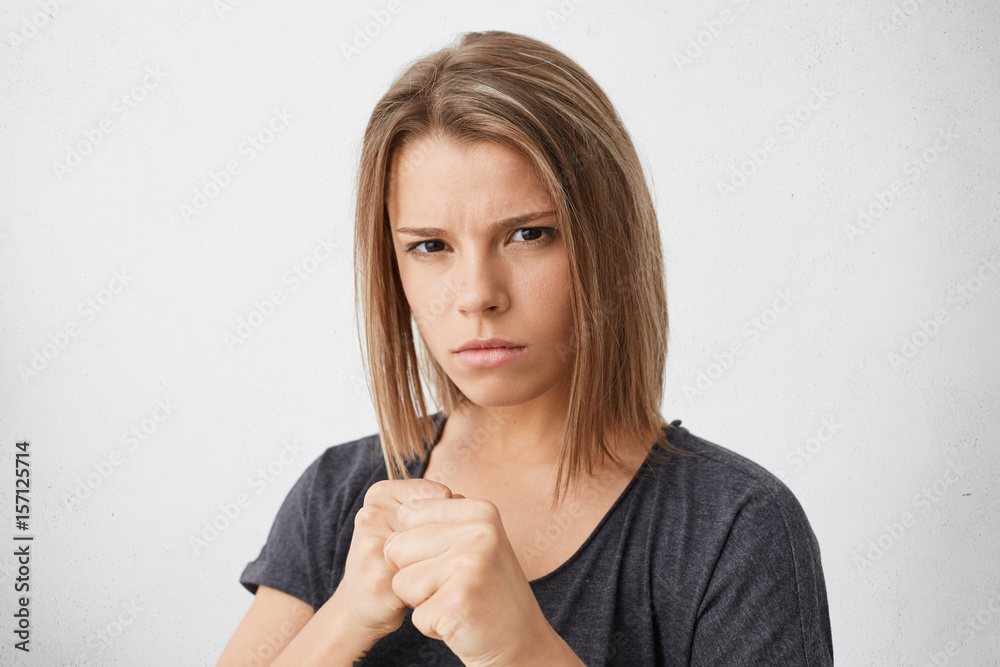 Aggressive young female keeping her fists ready to fight and defense ...