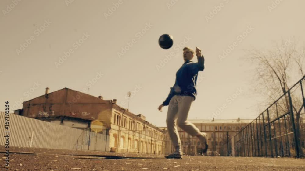 Young football player dribbling, awry kicking ball and disappointedly ...