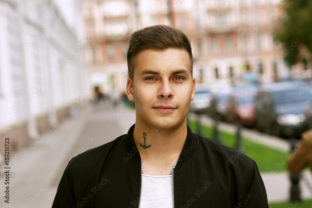 Outdoor street portrait of young handsome man with short haircut ...