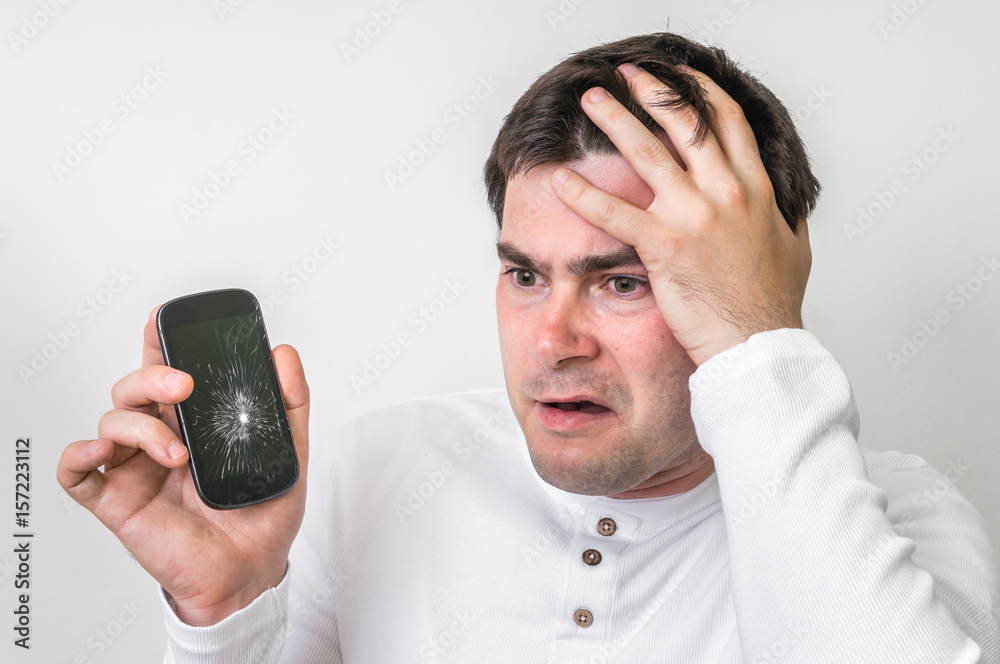 Sad man is holding mobile phone with broken screen Stock Photo | Adobe ...