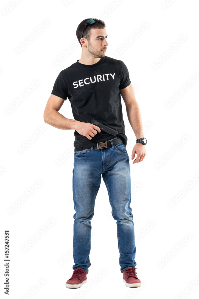 Cautious undercover agent taking gun attached on belt looking away ...