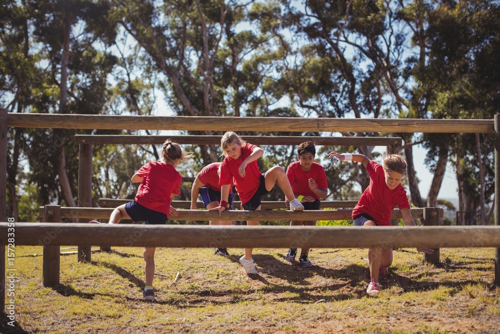 Kids jumping over the hurdles during obstacle course training Stock ...