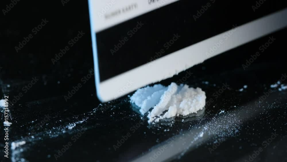 Drug Abuse. Forming two lines of drug powder with a plastic card ...
