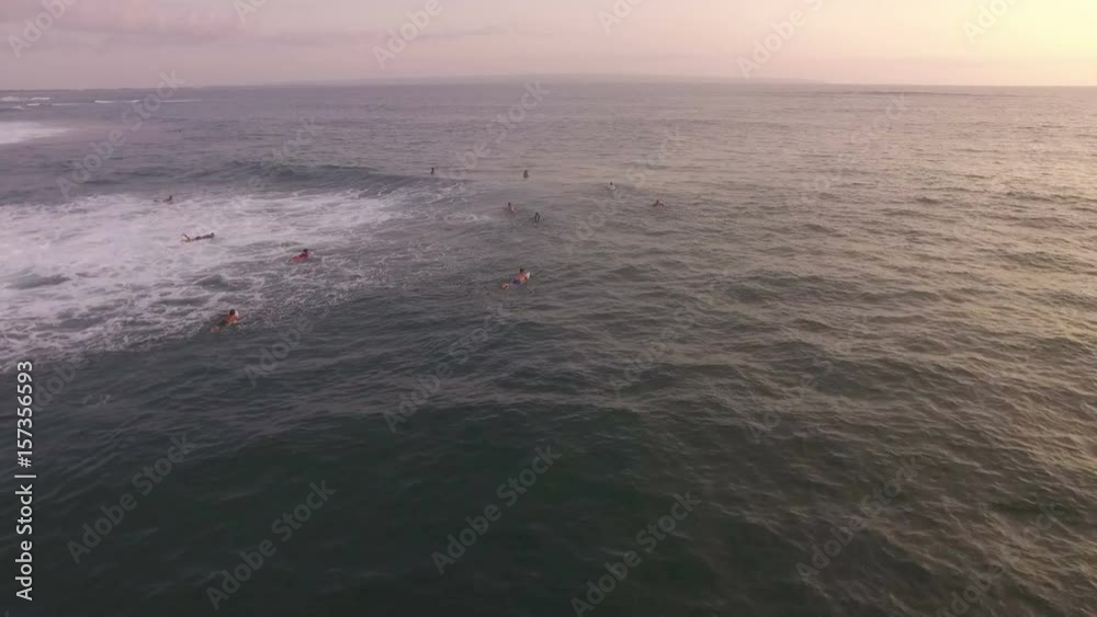 Bird eye view of surfers swimming on boards in blue ocean water with ...