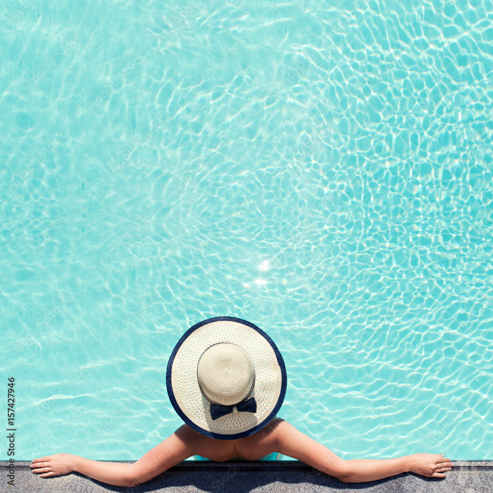 Beautiful woman sunbathing by the pool top view. Summer background for ...