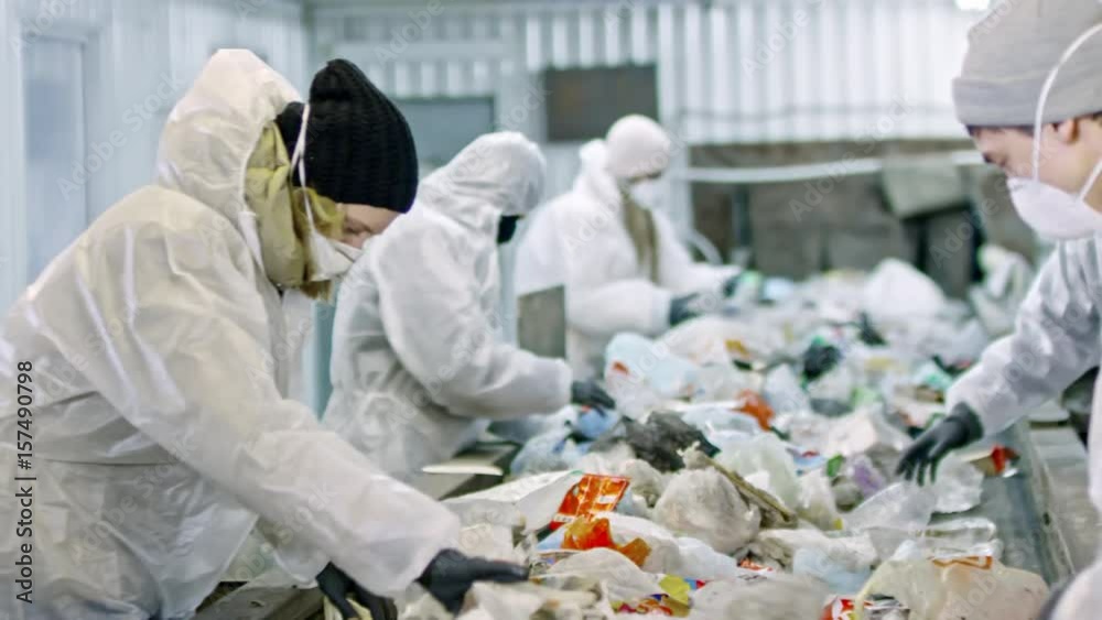 PAN with slow motion of workers of garbage recycling factory standing ...