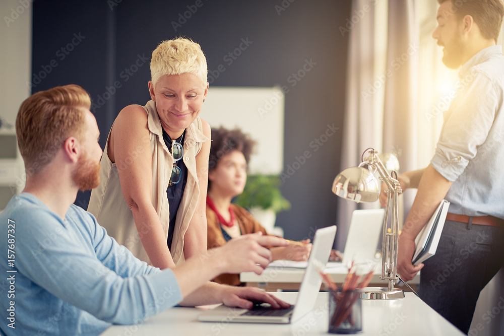 Caucasian businesswoman giving advice to her colleague while standing ...