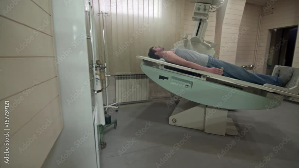 Middle aged male radiologist using scanner to performs x-ray imaging on ...