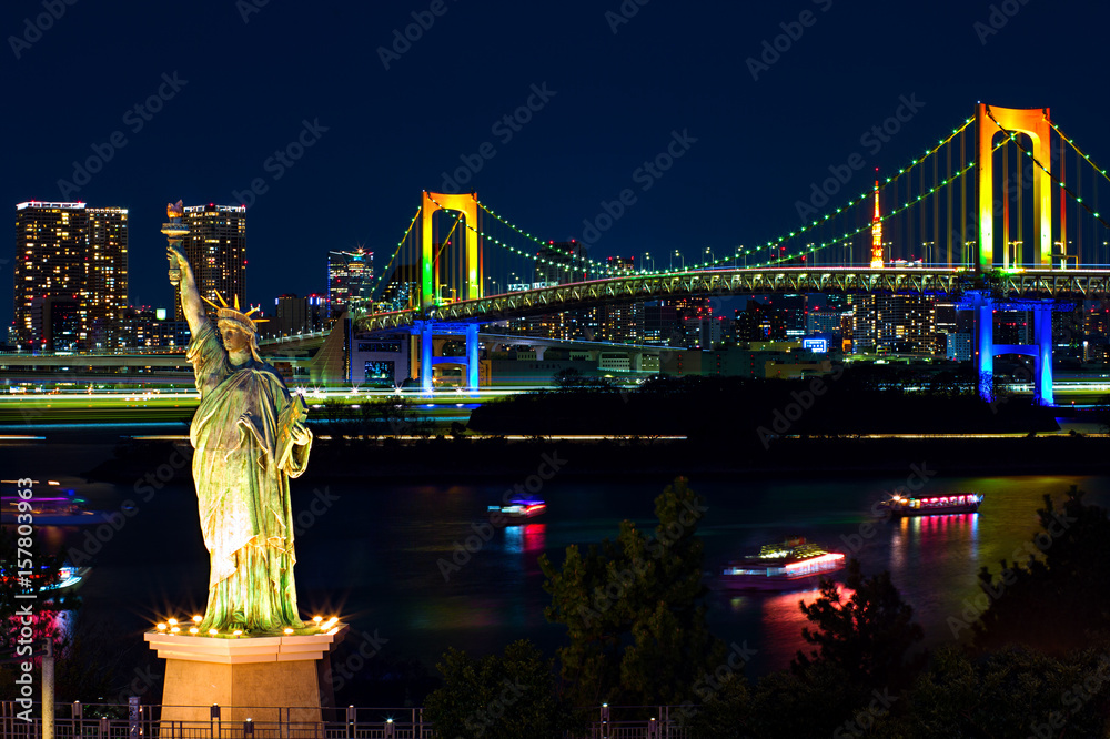 Rainbow Bridge and the Statue of Liberty at night with the bridge lit ...
