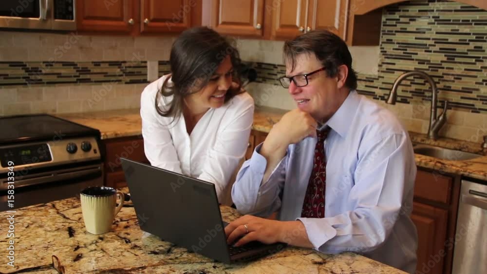 Husband and wife working from home together are talking , laughing ...