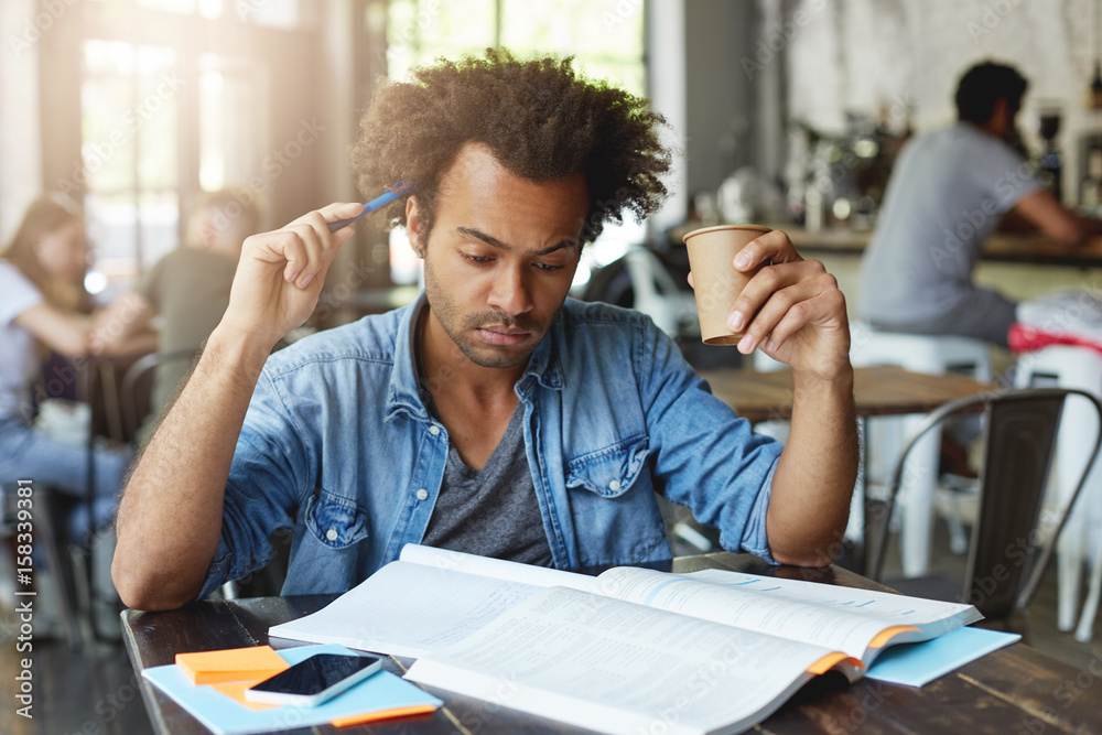 Concentrated thoughtful black European student with Afro hairstyle ...
