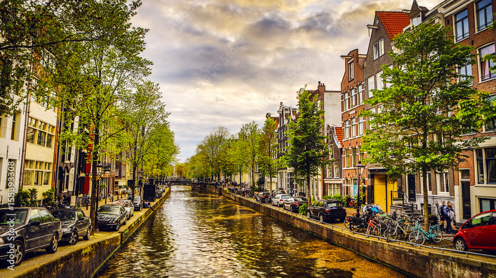 The most famous canals and embankments of Amsterdam city during sunset ...