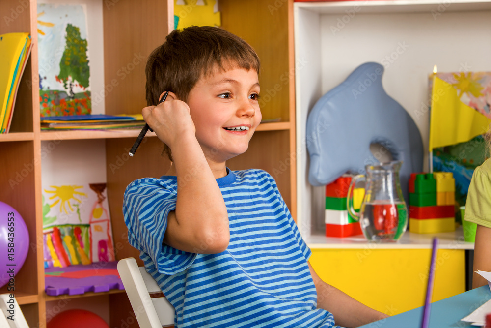 Small student boy painting in art school class. Child drawing by paints ...