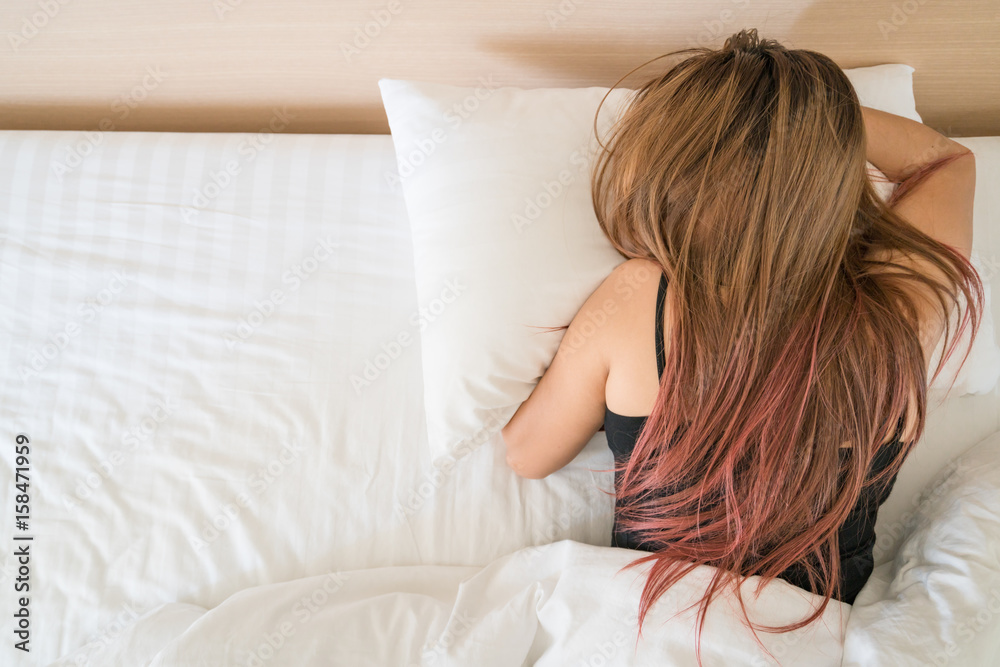Top view of back side woman sleeping on the bed. Above view of young ...