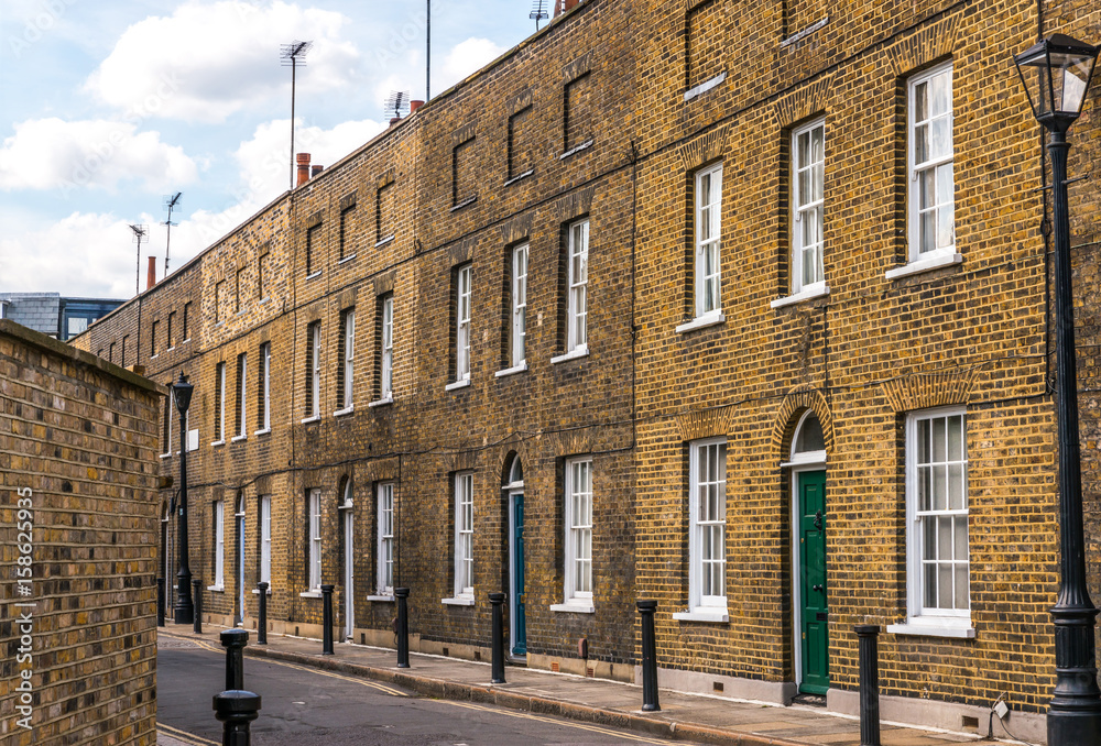 Typical old English buildings, low brick buildings across a narrow ...