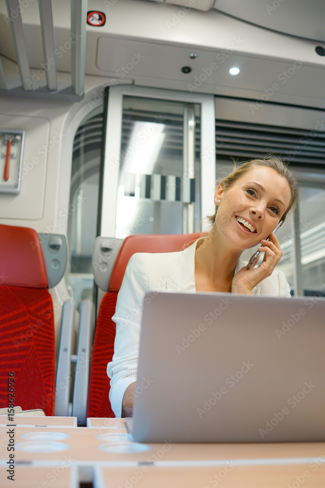 Businesswoman in train talking on phone Stock Photo | Adobe Stock