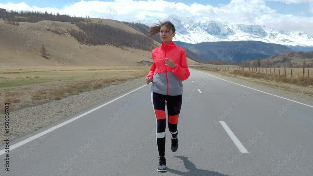 Woman runner running on open road in countryside. Female jogger ...