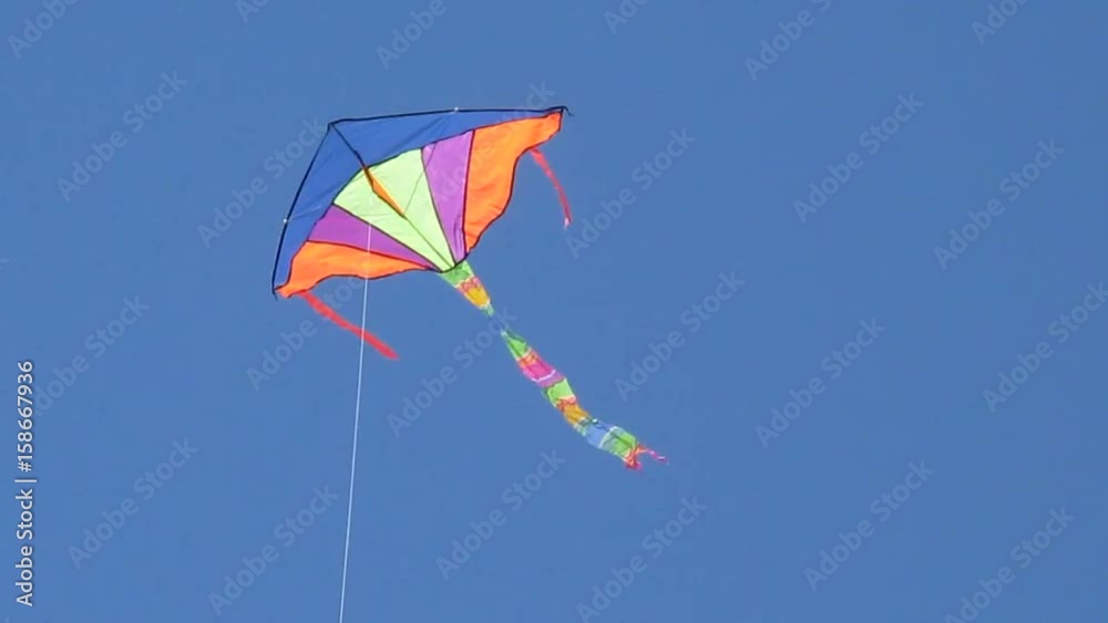 colorful striped kite flying in blue sky Stock Video | Adobe Stock