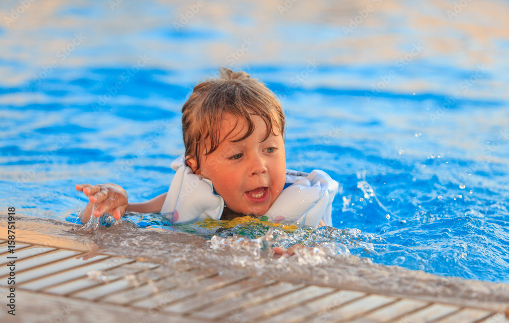Cute little child swimming with life jacket in outdoor pool Stock Photo ...