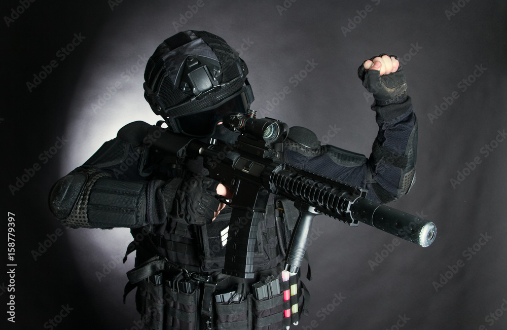 Member of the SWAT squad with an assault rifle in a black uniform on ...