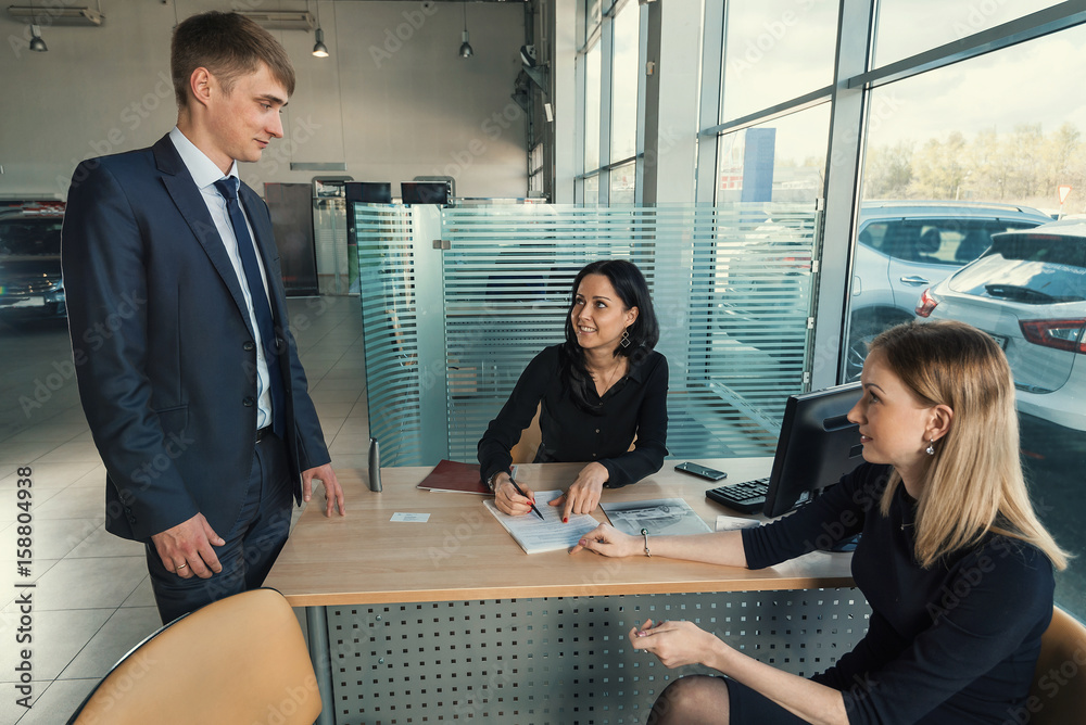 Man in a suit and an office worker signing a contract with a girl ...