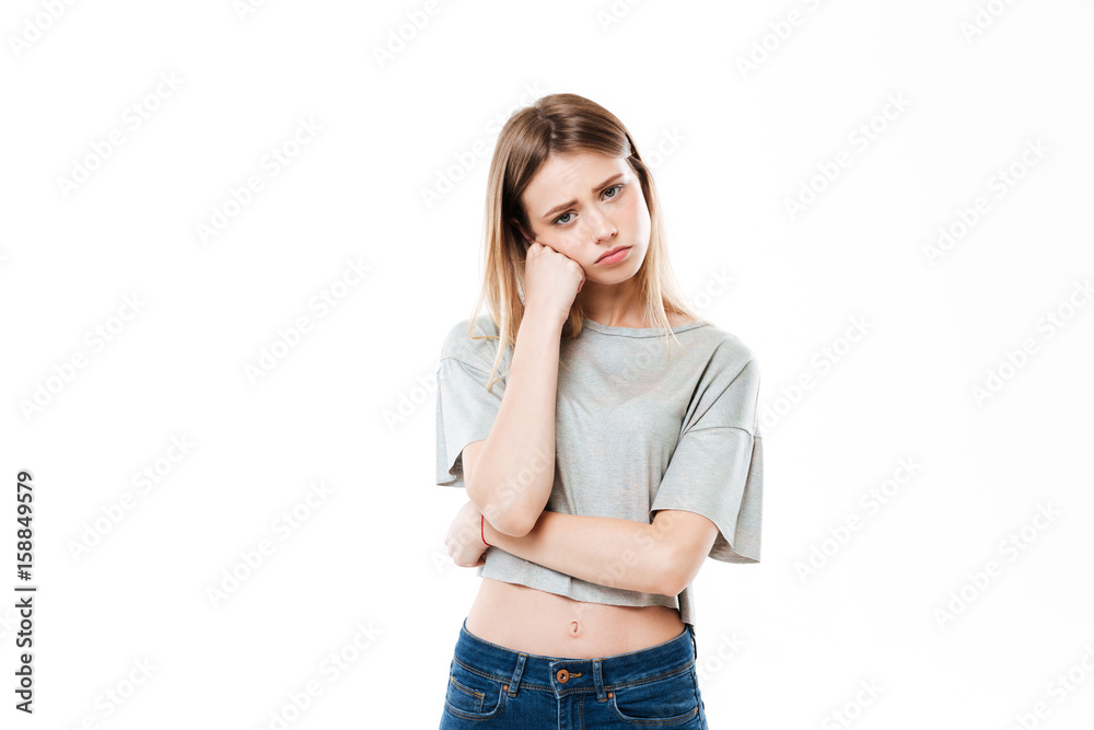 Sad young woman standing isolated over white background Stock Photo ...