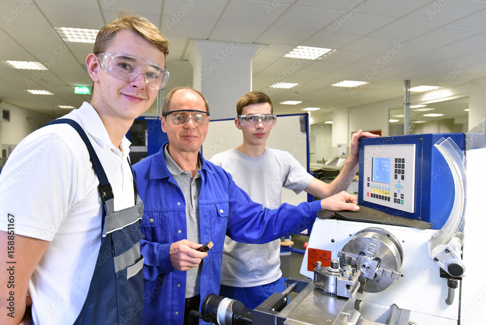jugendliche Azubis und Ausbilder an einer CNC Drehmaschine - moderne ...